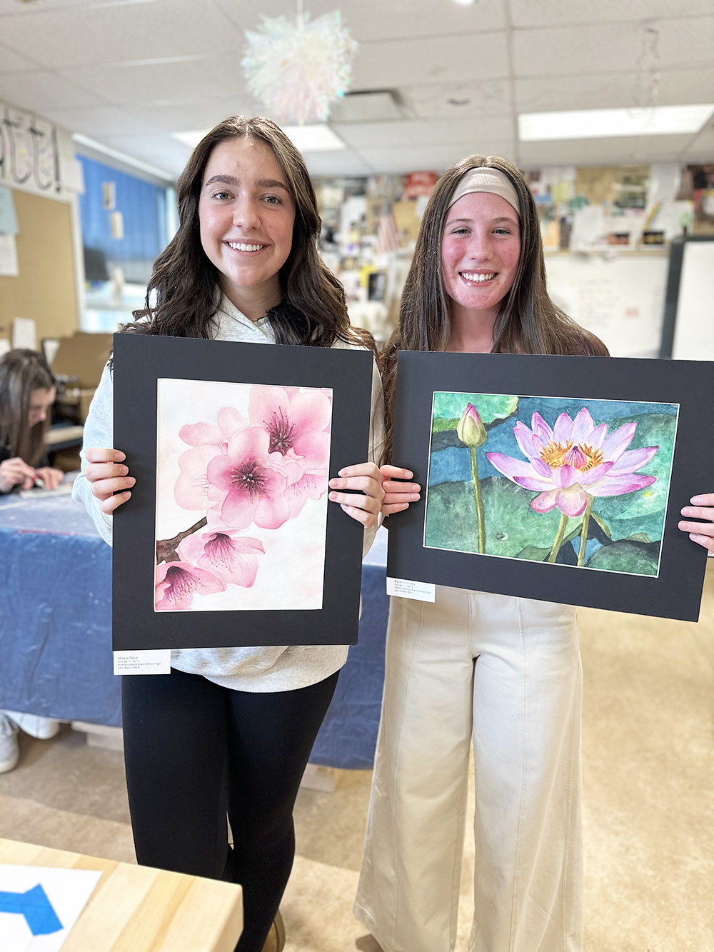 Maya Deur and Rylan Carney (holding up their watercolor paintings ...